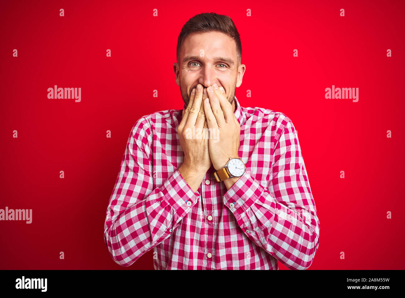 Young handsome man over red isolated background laughing and ...