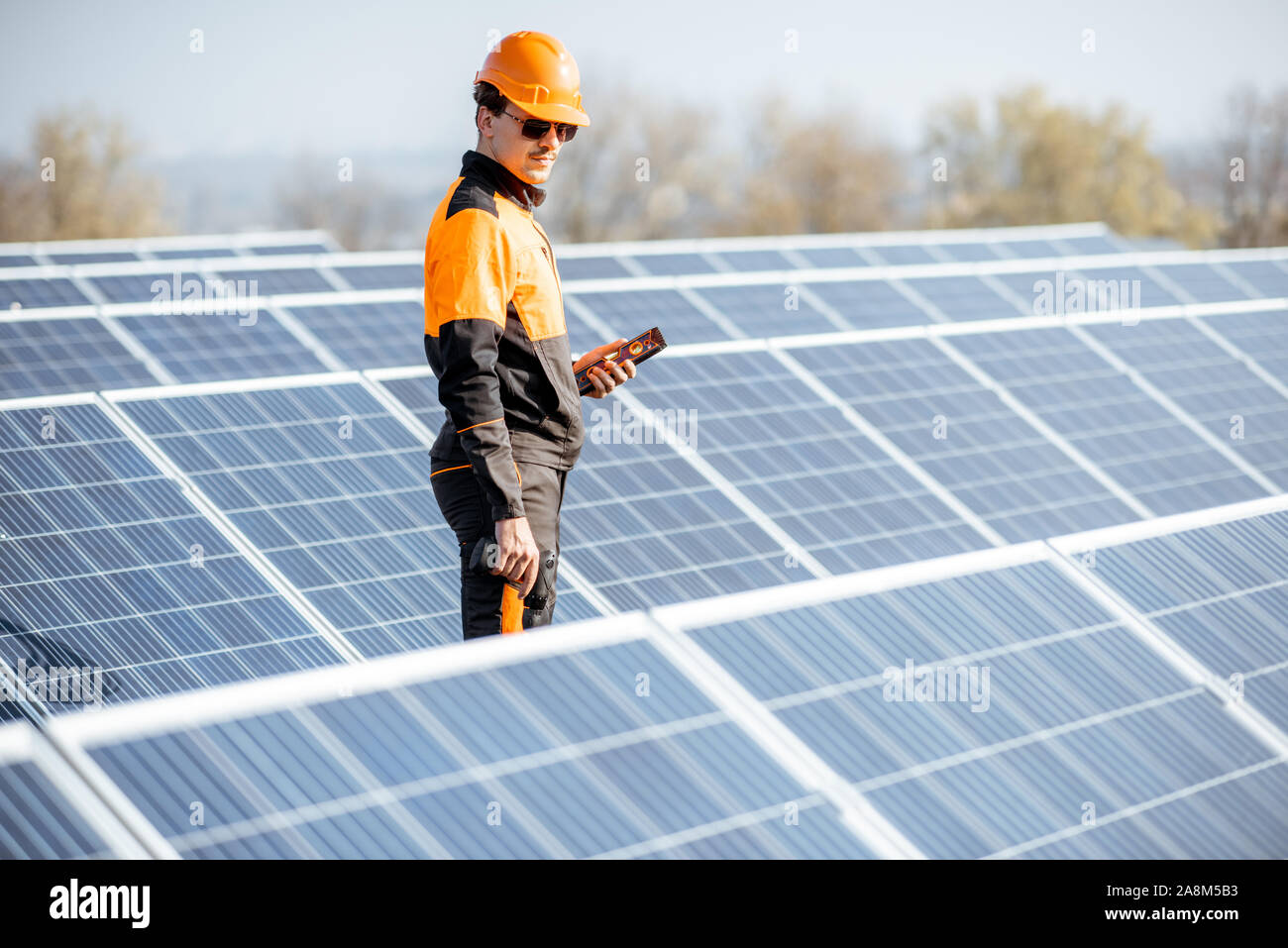 Portrait of a well-equipped worker in protective orange clothing ...