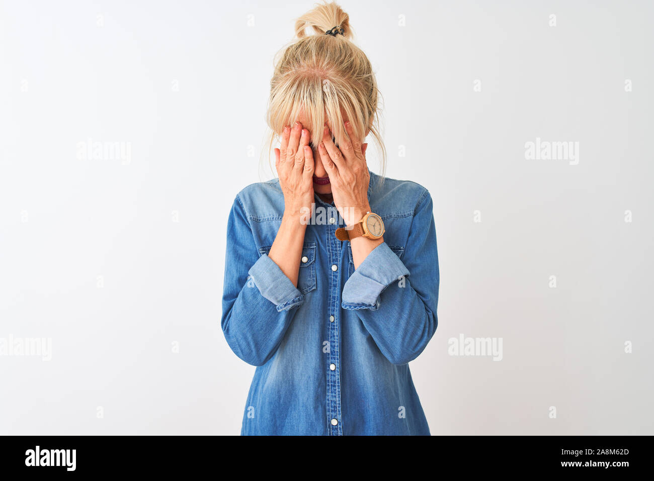 Middle age woman wearing casual denim shirt standing over isolated ...