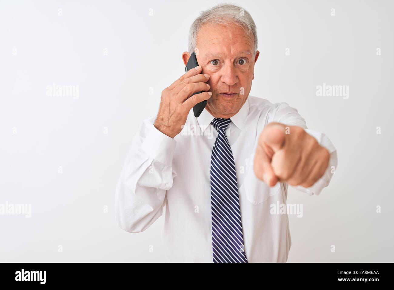 Senior grey-haired businessman talking on the smartphone over isolated ...