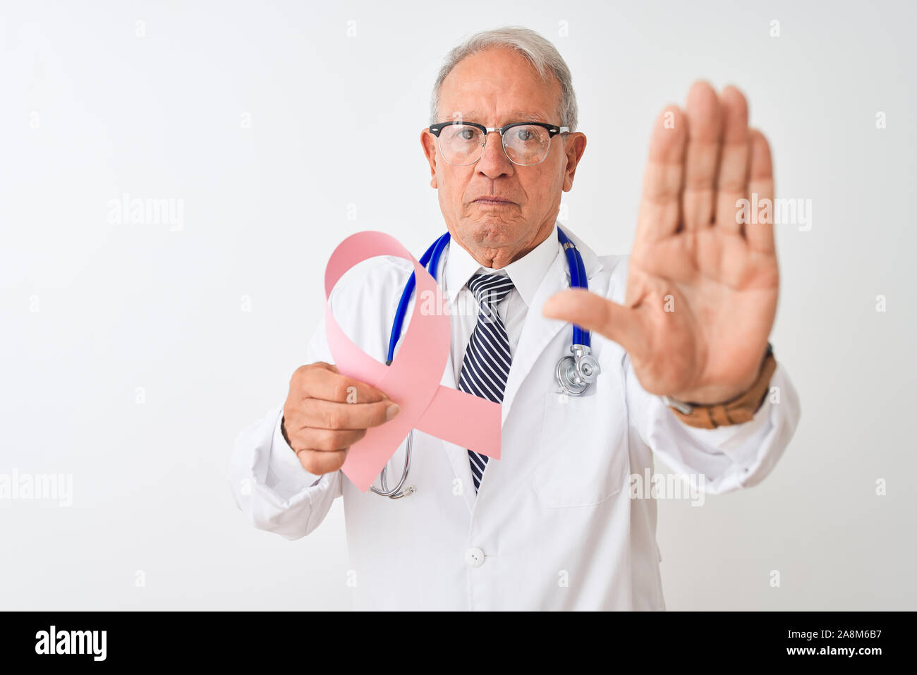 Senior grey-haired doctor man holding cancer ribbon over isolated white ...
