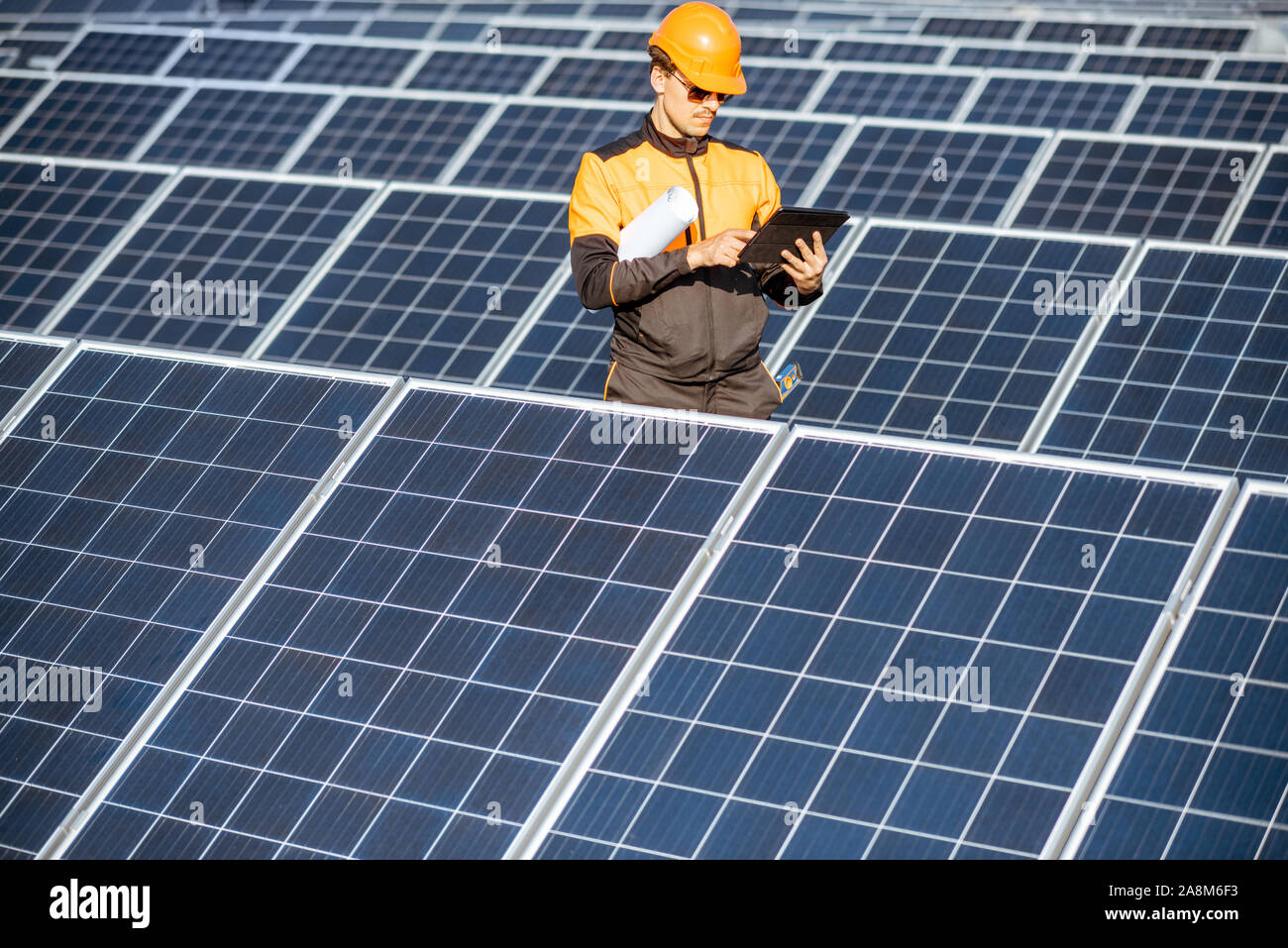 Engineer in protective workwear carrying out service of solar panels ...
