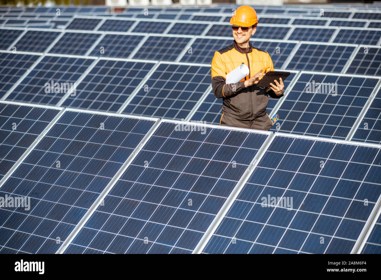 Engineer in protective workwear carrying out service of solar panels ...