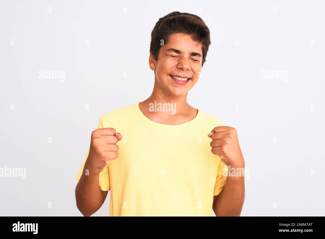 Handsome teenager boy standing over white isolated background very ...