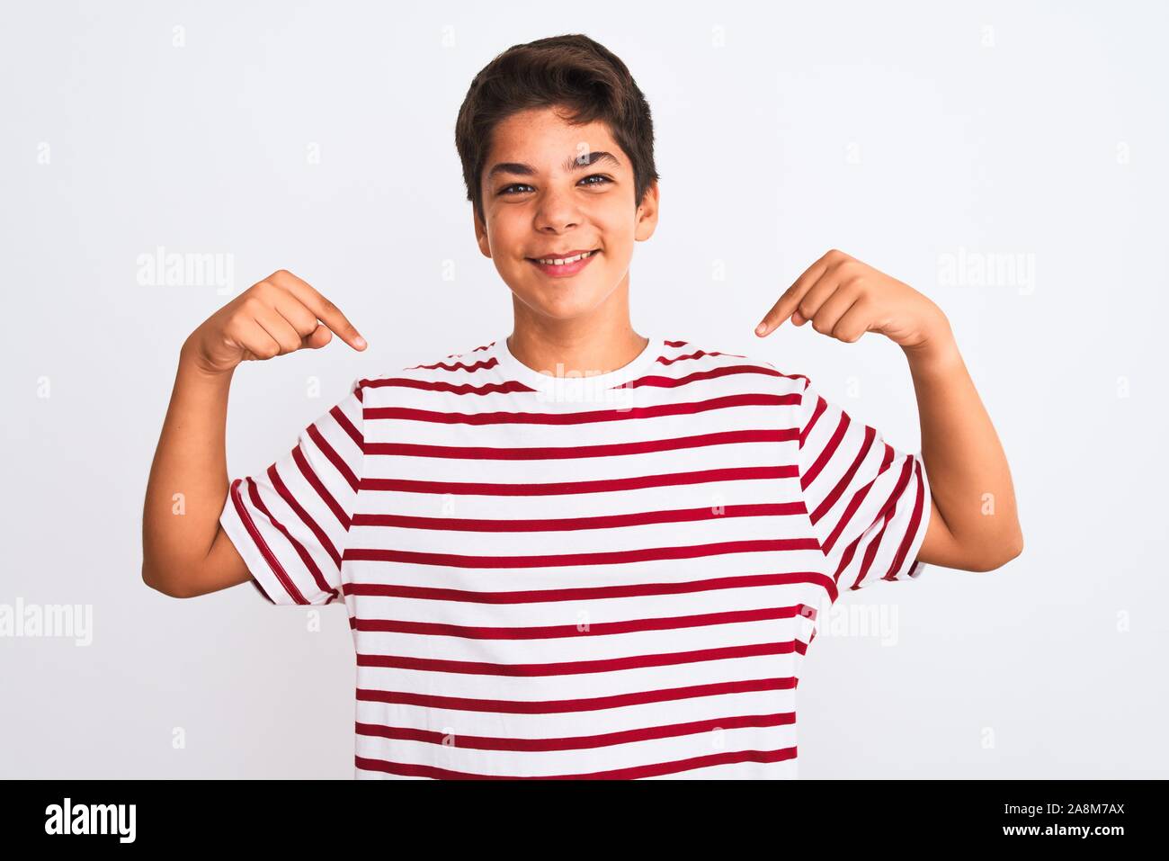 Handsome teenager boy standing over white isolated background looking ...