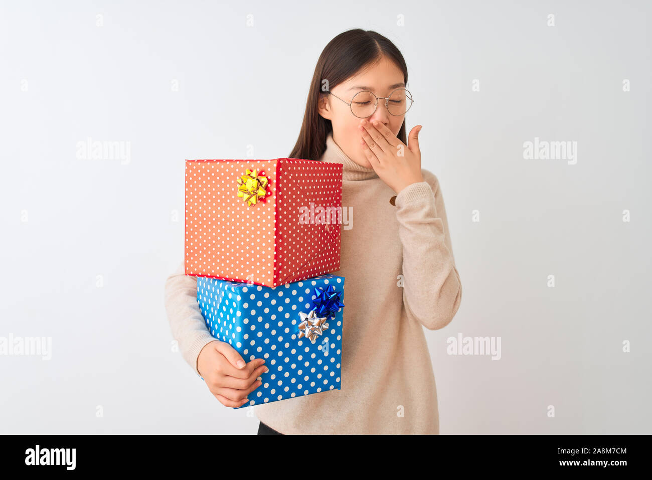Young chinese woman holding birthday gifts over isolated white ...