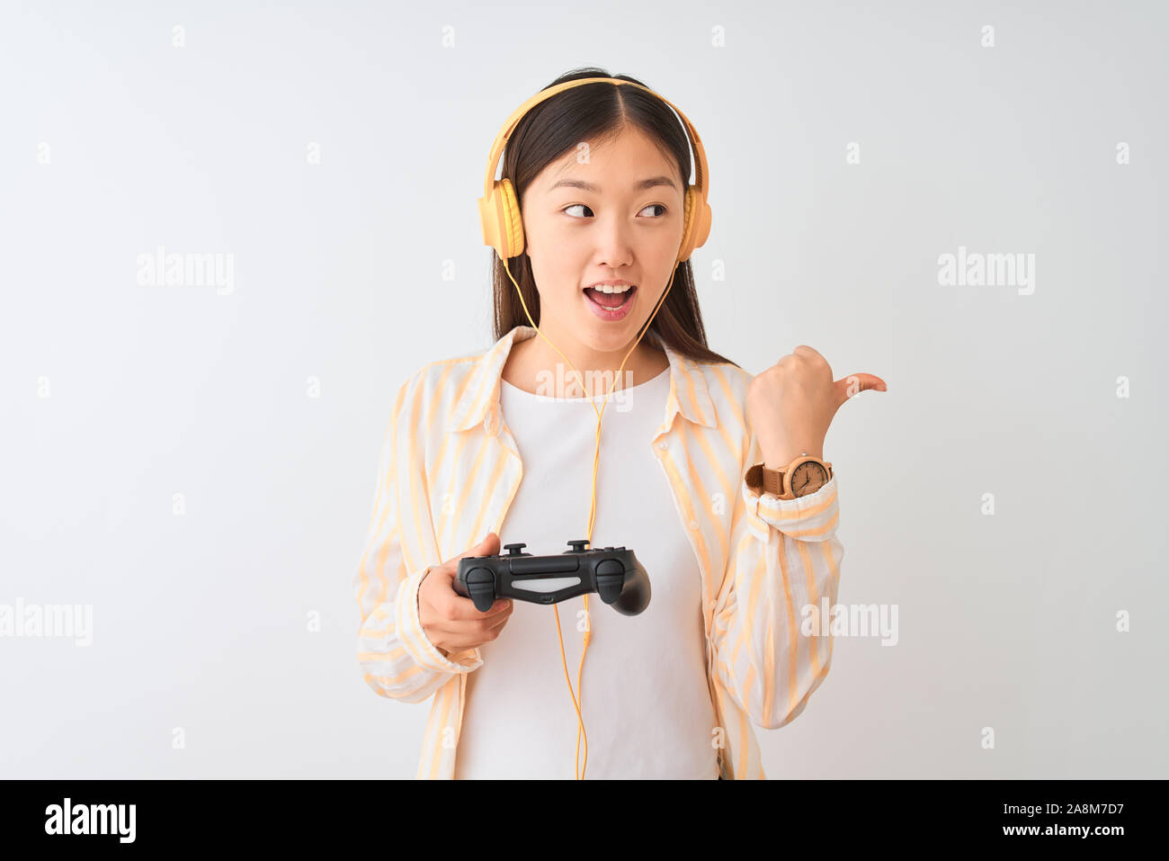 Chinese gamer woman playing video game using headphones over isolated ...