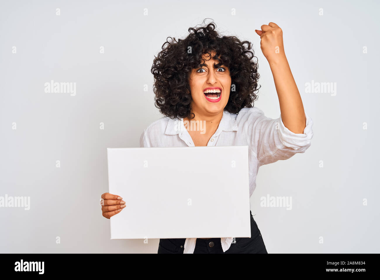 Young arab woman with curly hair holding banner over isolated white ...