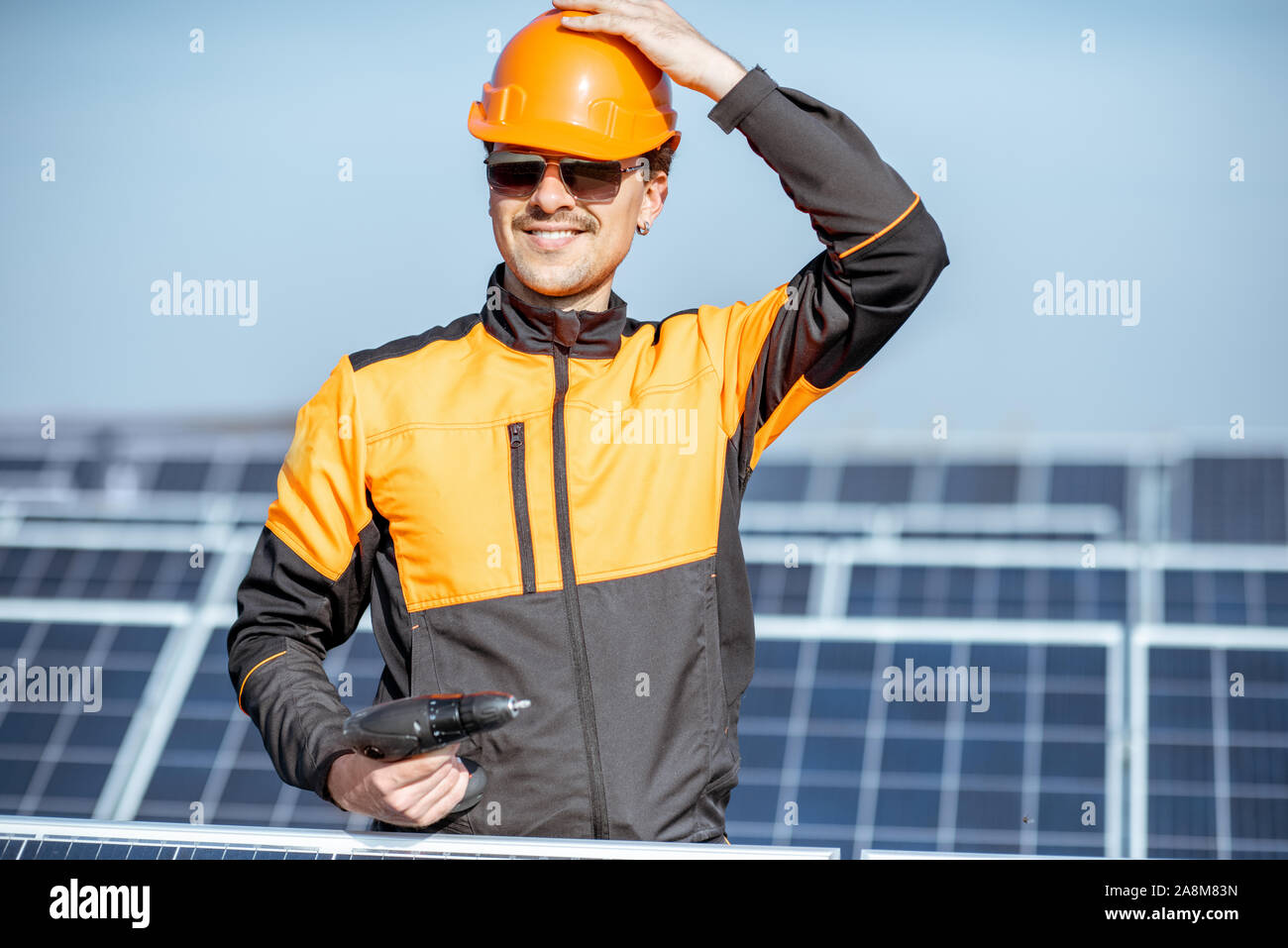Portrait of a well-equipped worker in protective orange clothing ...