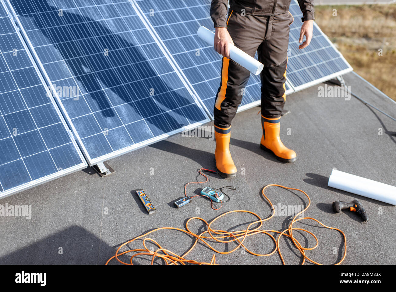 Installing solar panels, close-up on a working tools. wires and man in ...