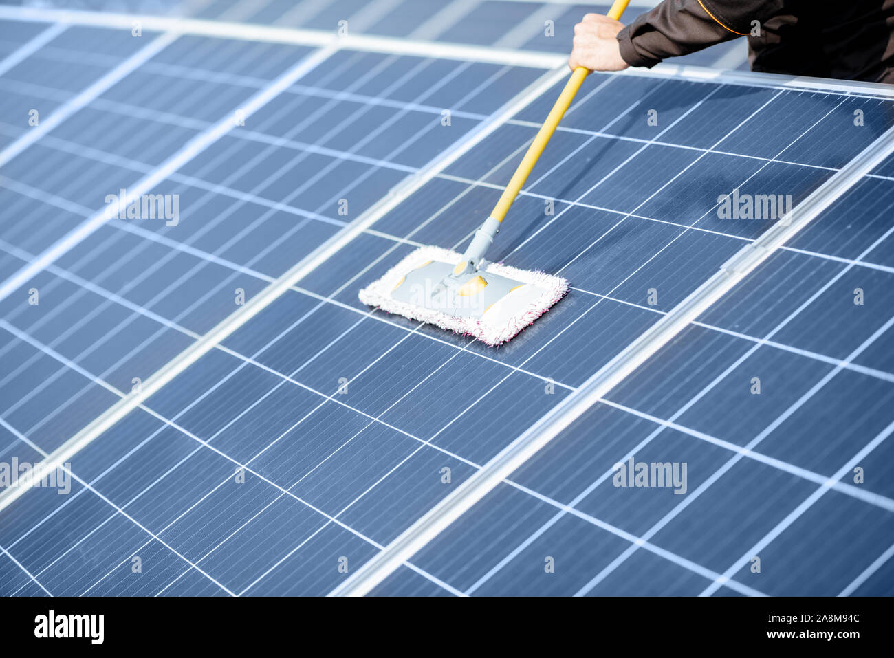 Close-up of professional cleaning of solar panels with a mob. Concept ...