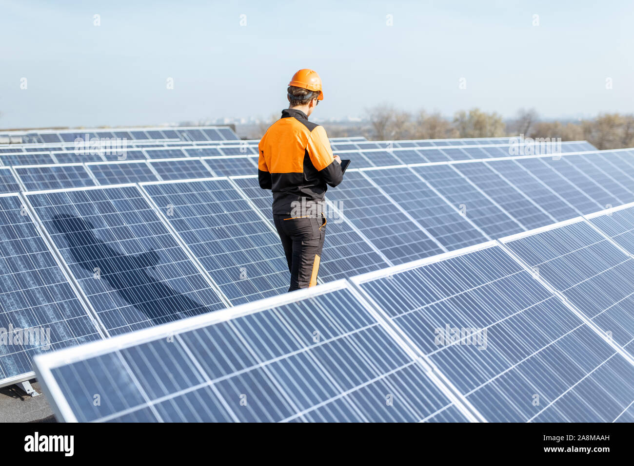 View on the rooftop solar power plant with engineer in protective ...