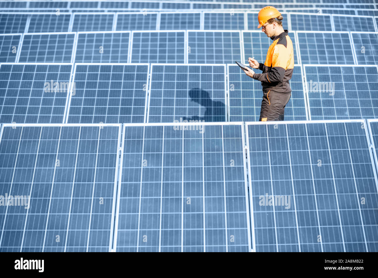 View on the rooftop solar power plant with engineer in protective ...