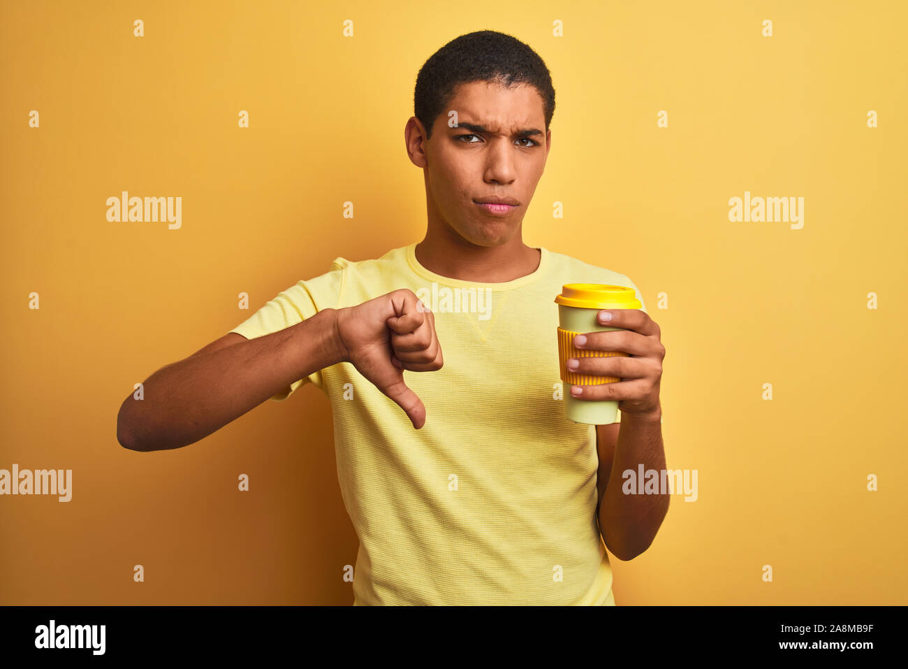 Young handsome arab man drinking take away coffee over isolated yellow ...