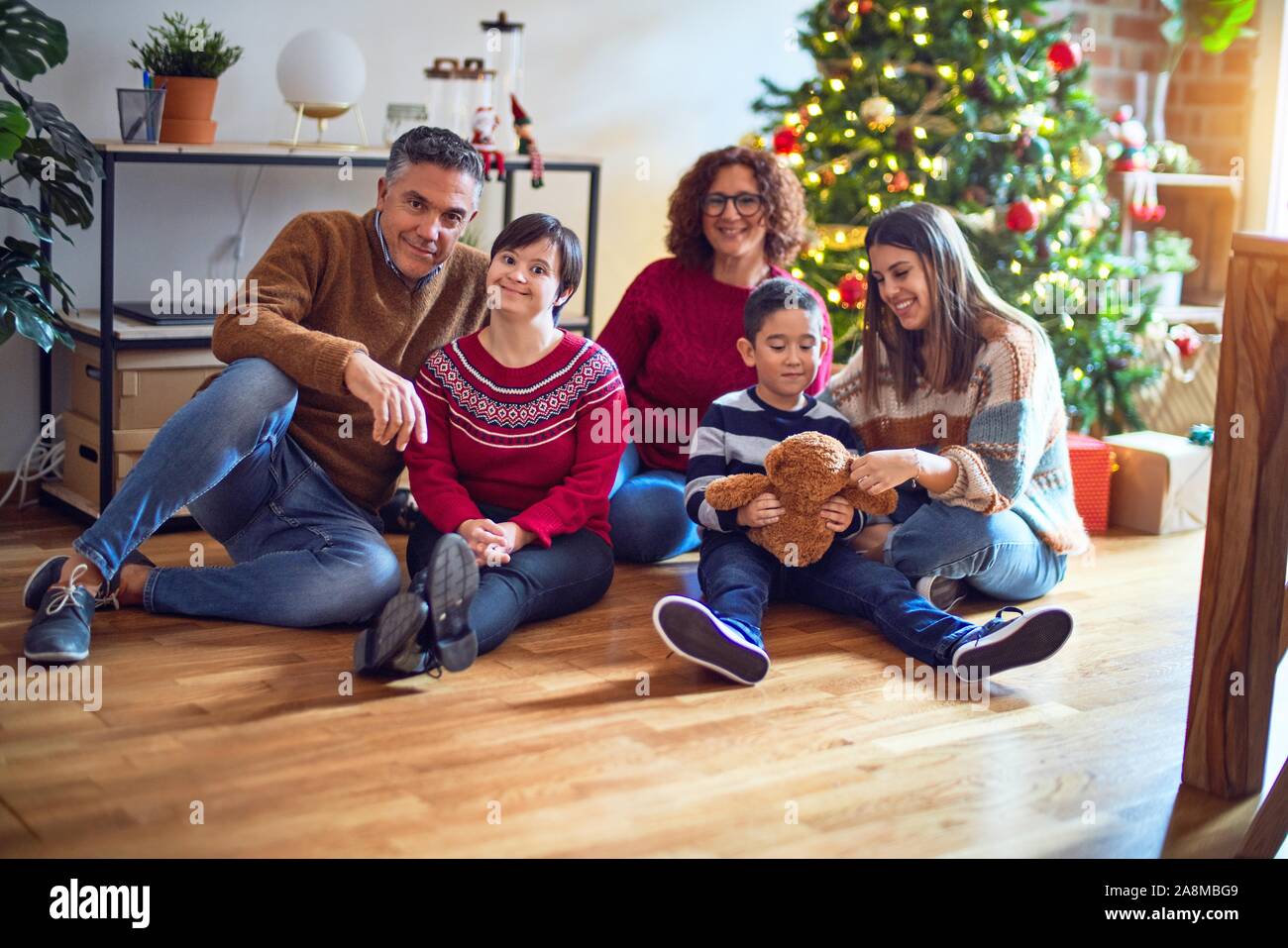 Beautiful family smiling happy and confident. Sitting on the floor and ...