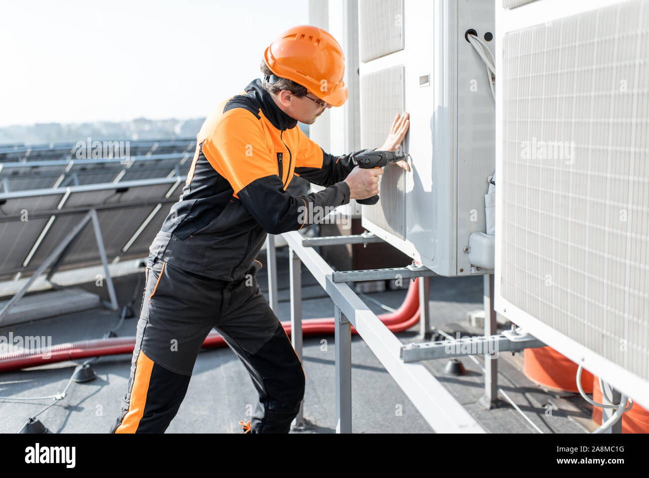 Professional workman in protective clothing installing or reparing ...