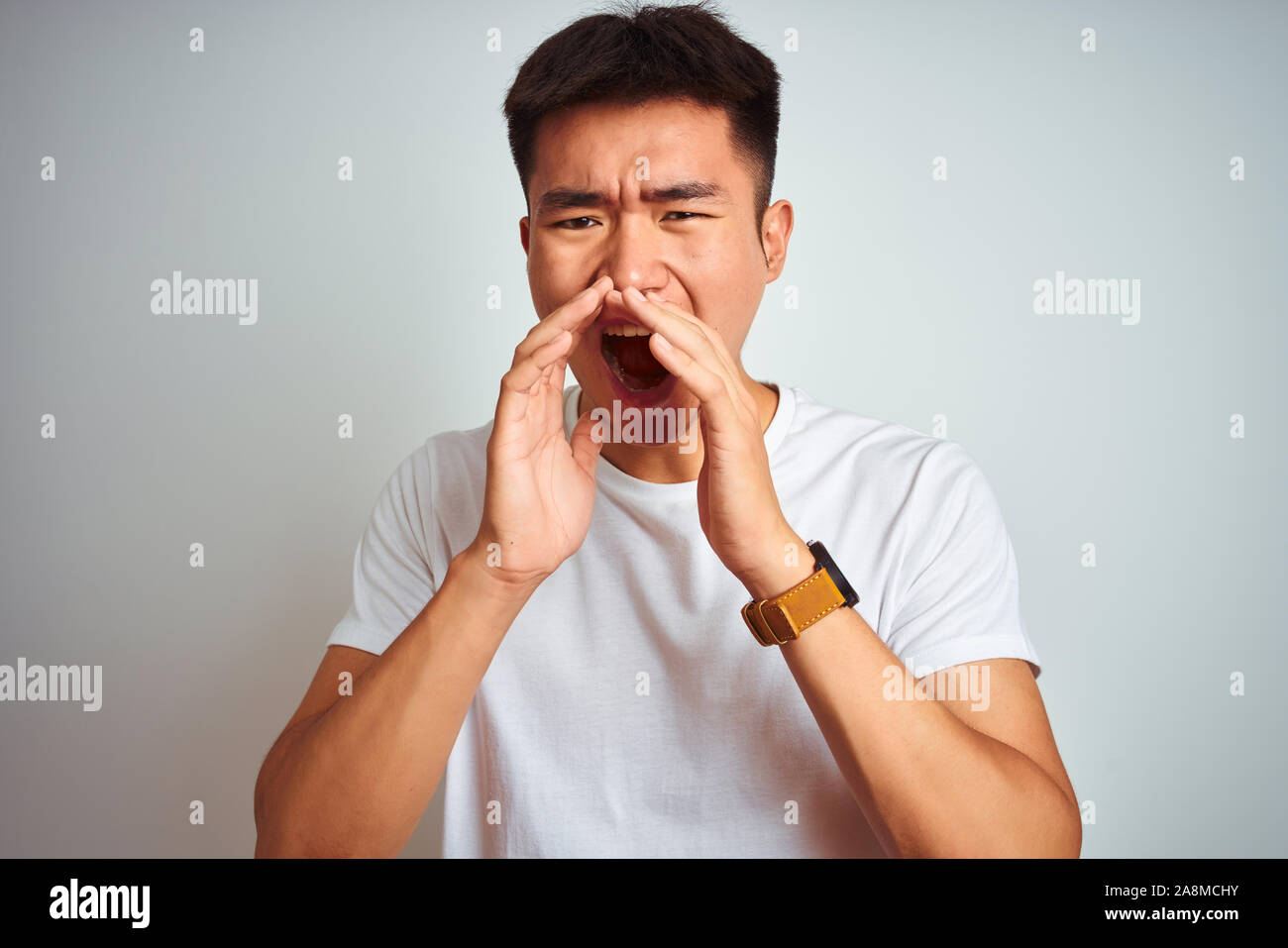Young asian chinese man wearing t-shirt standing over isolated white ...