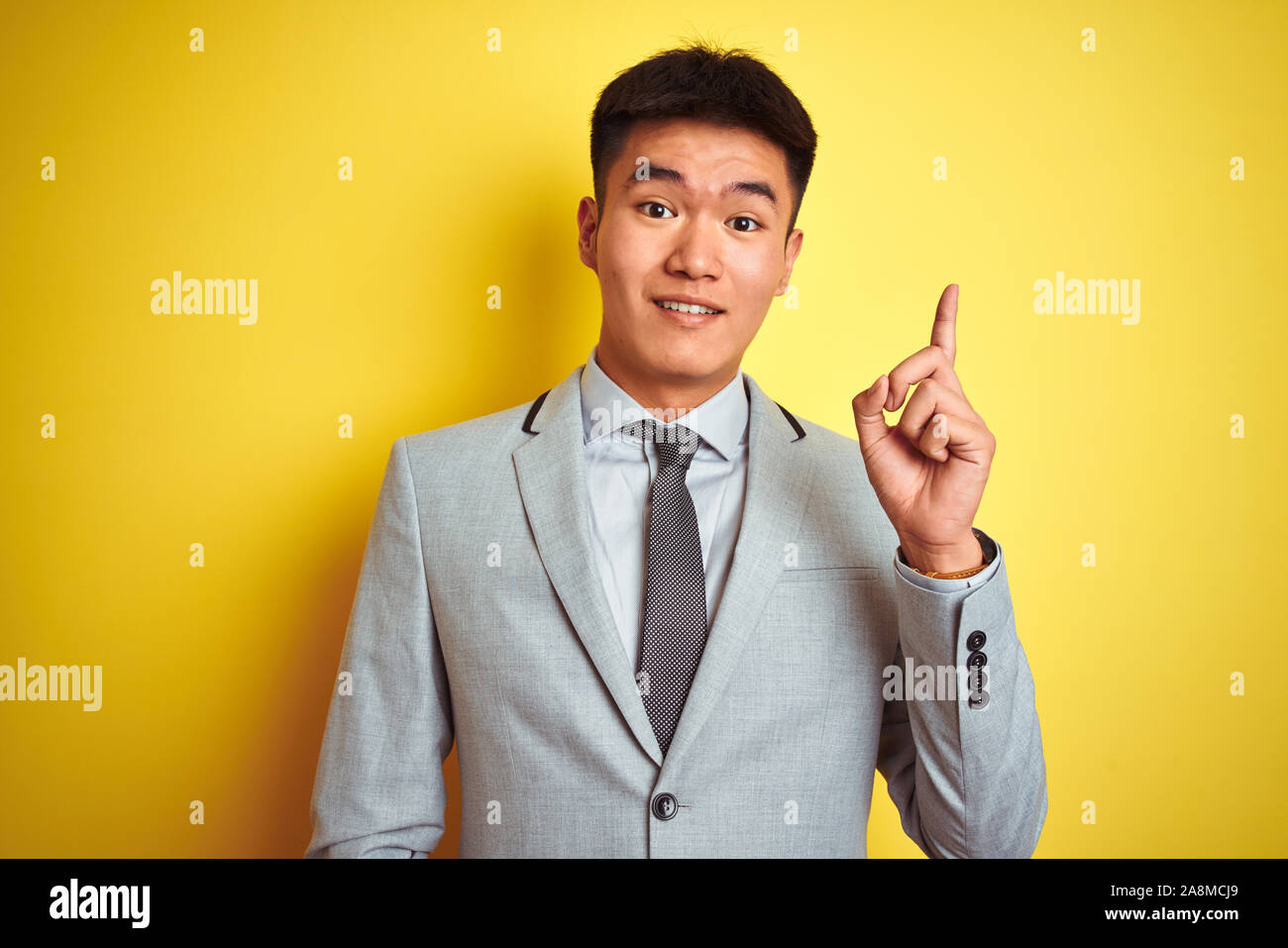 Asian chinese businessman wearing suit and tie standing over isolated ...