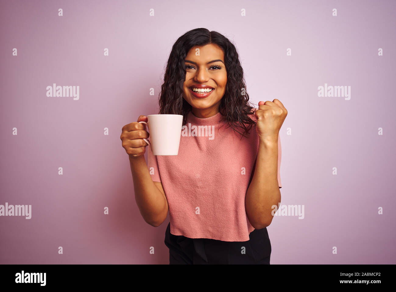Transsexual transgender woman drinking cup of coffee over isolated pink ...