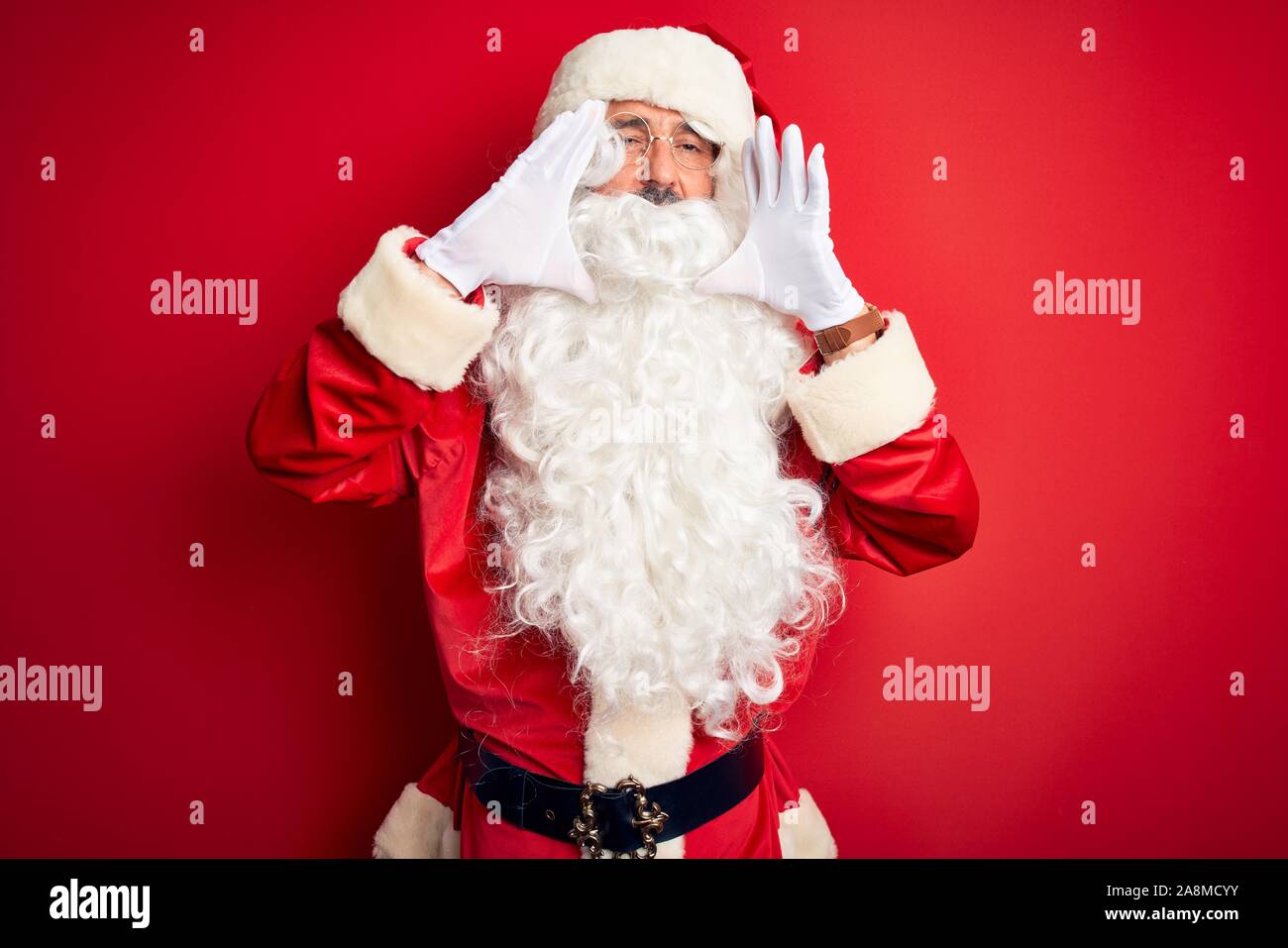 Middle age handsome man wearing Santa costume standing over isolated ...