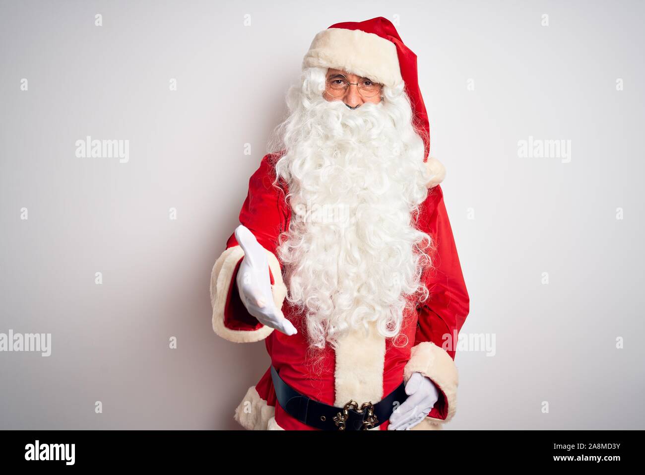 Middle age handsome man wearing Santa costume standing over isolated ...