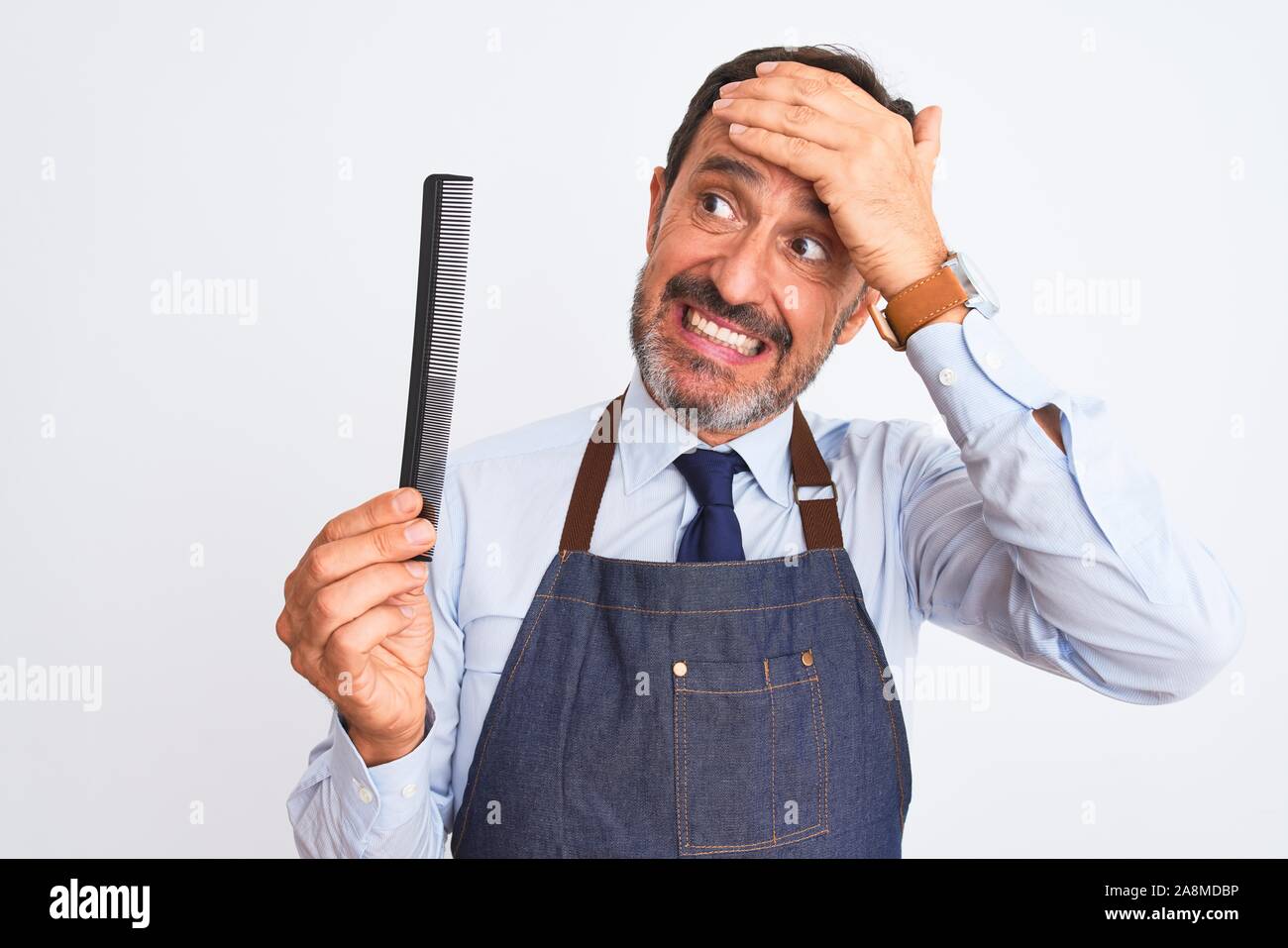 Middle age barber man wearing apron holding hair comb over isolated ...