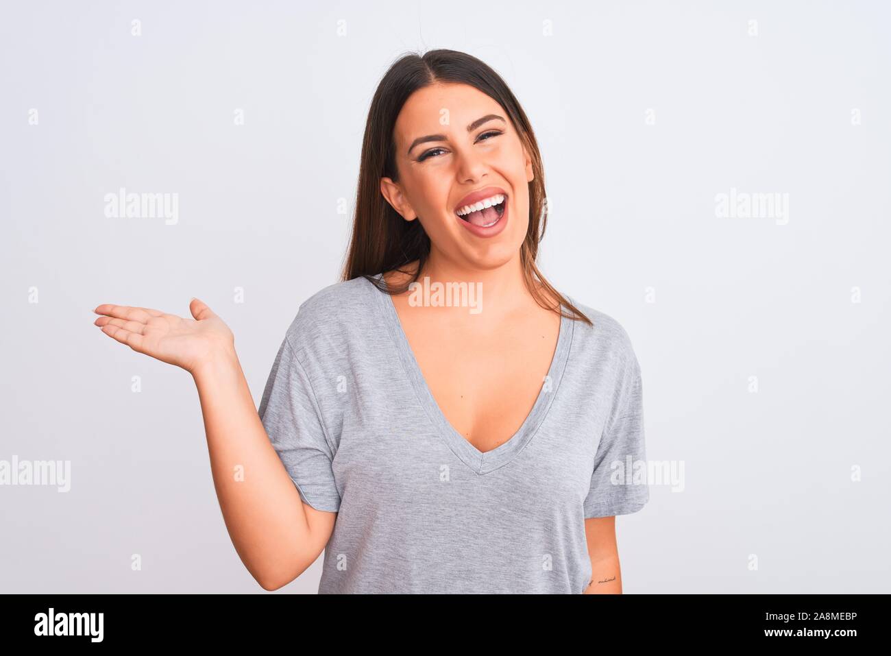 Portrait of beautiful young woman standing over isolated white ...