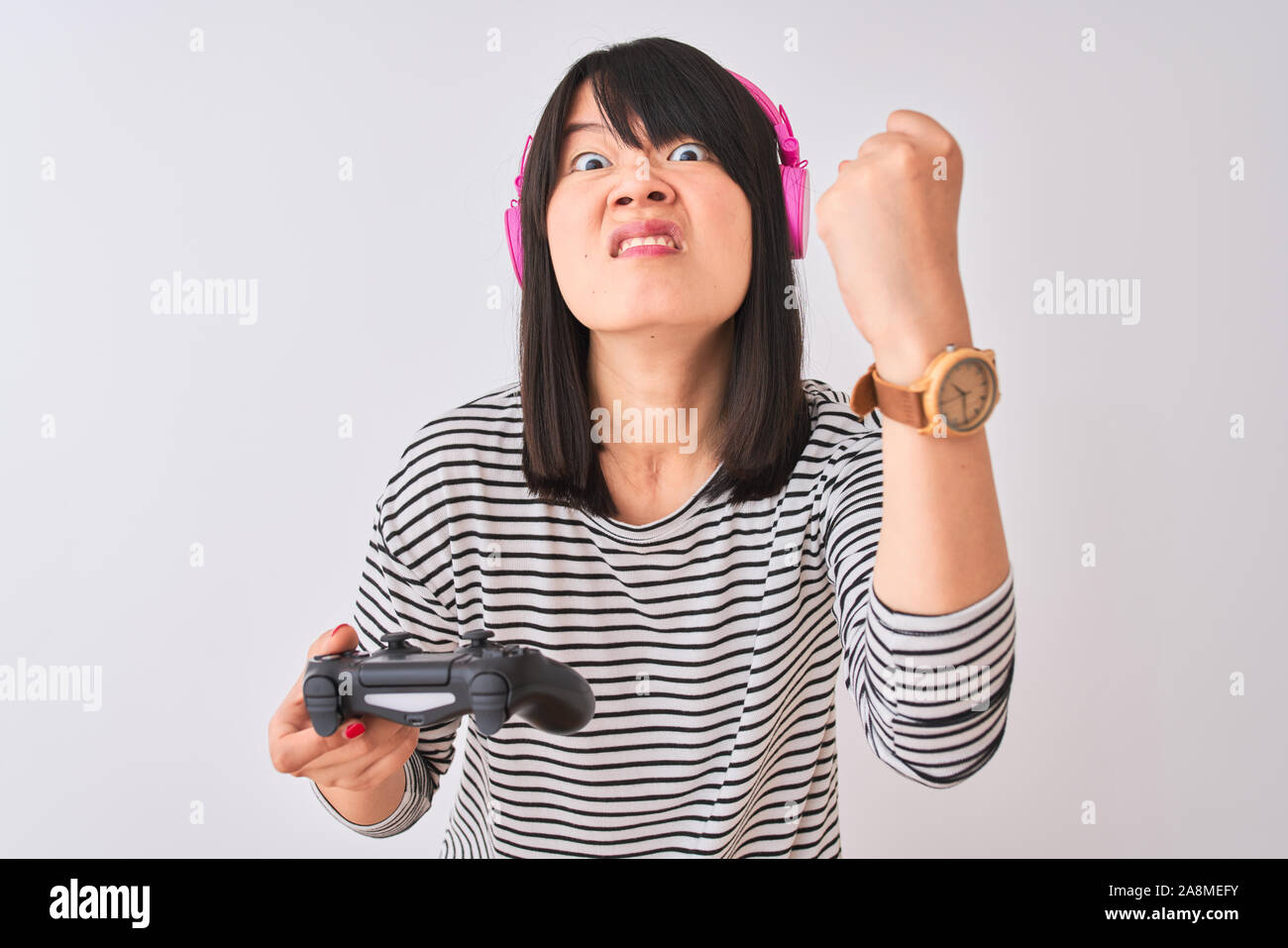 Chinese gamer woman playing video game using headphones over isolated ...