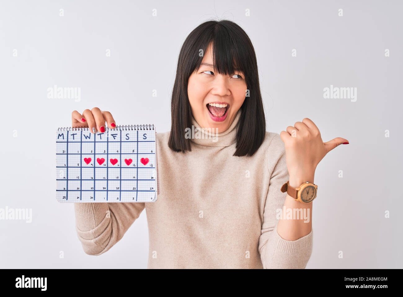 Young beautiful Chinese woman holding menstruation calendar over ...