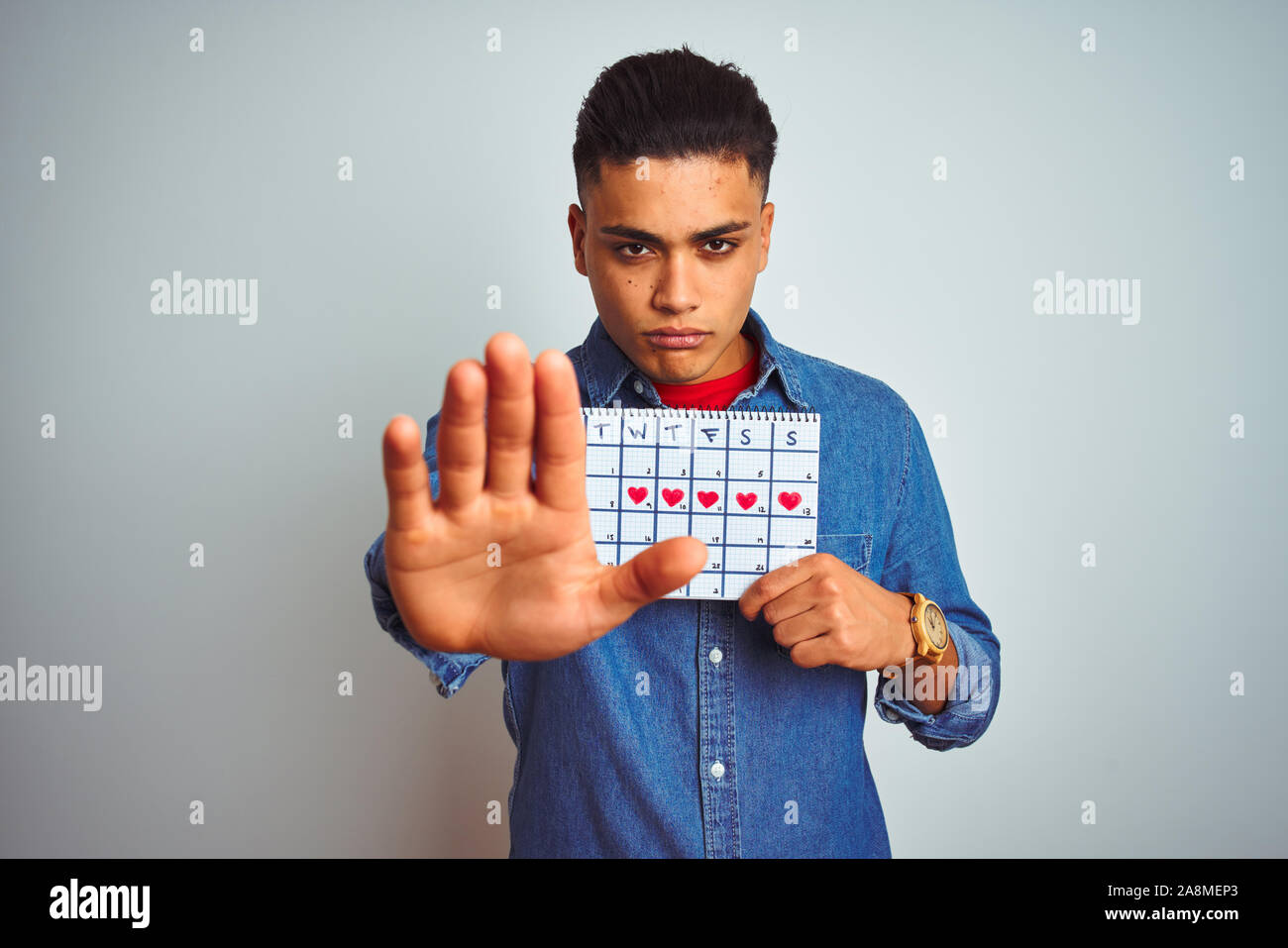 Young brazilian man holding calendar standing over isolated white ...