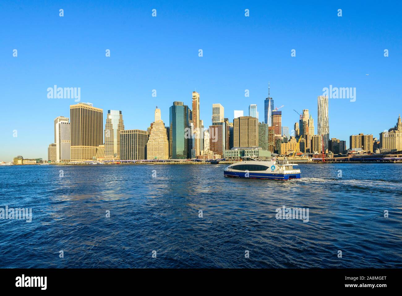 Ferry, NYC Ferry on the East River, view from Pier 1 to the skyline of ...