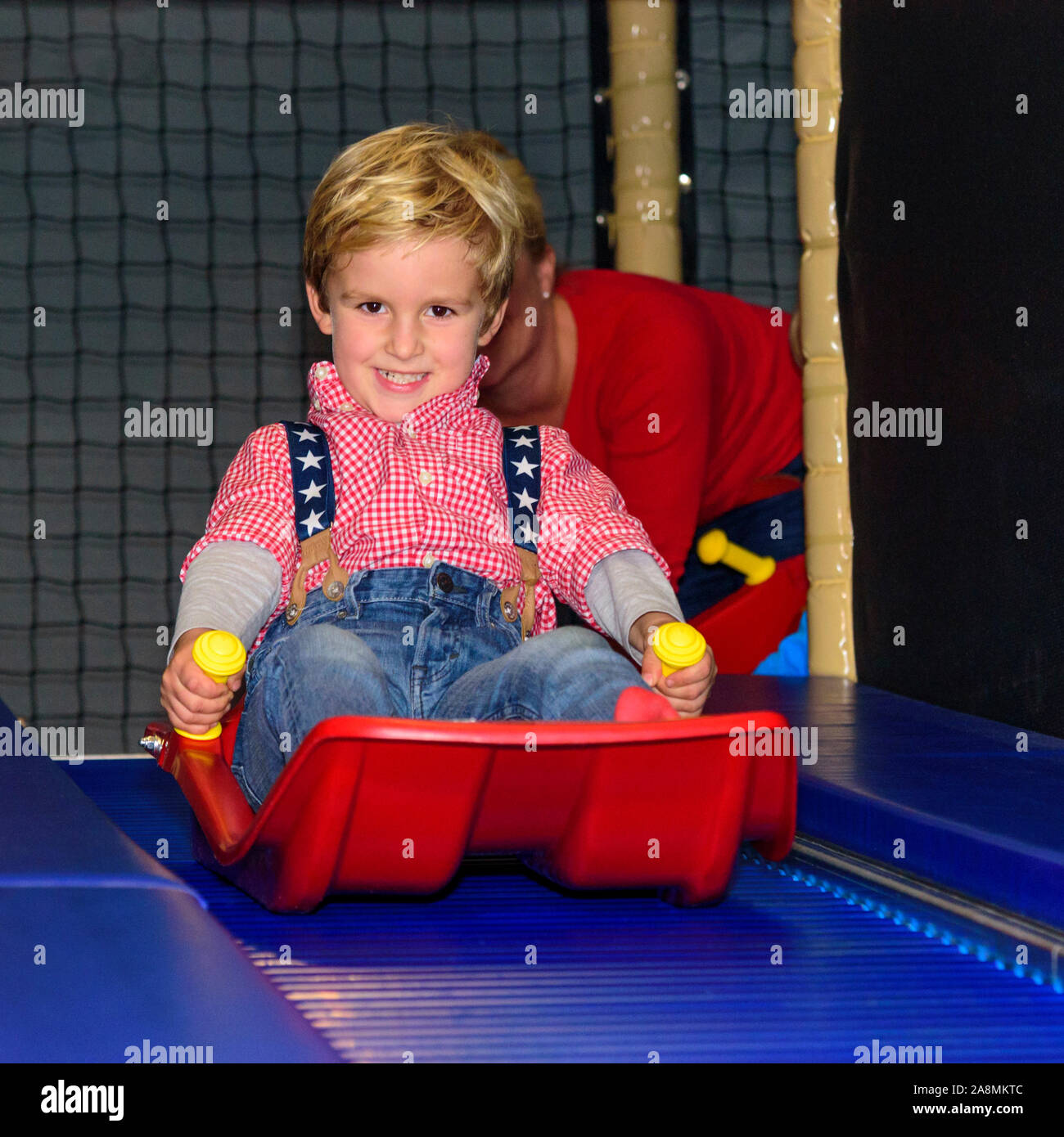 Sliding fun in indoor playground Stock Photo - Alamy