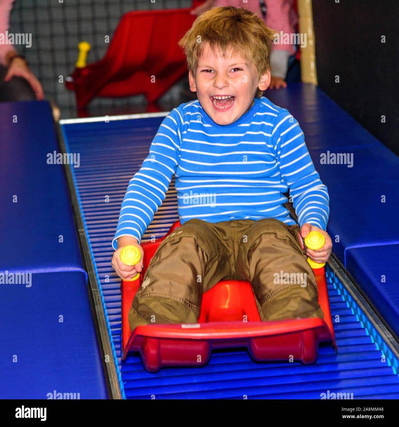 Sliding fun in indoor playground Stock Photo - Alamy