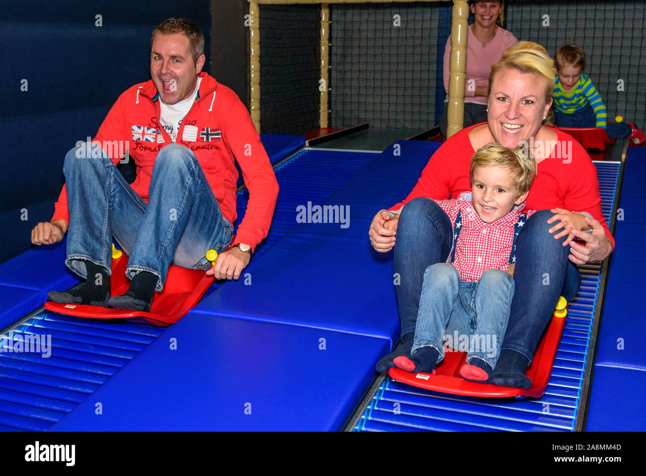 Sliding fun in indoor playground Stock Photo - Alamy