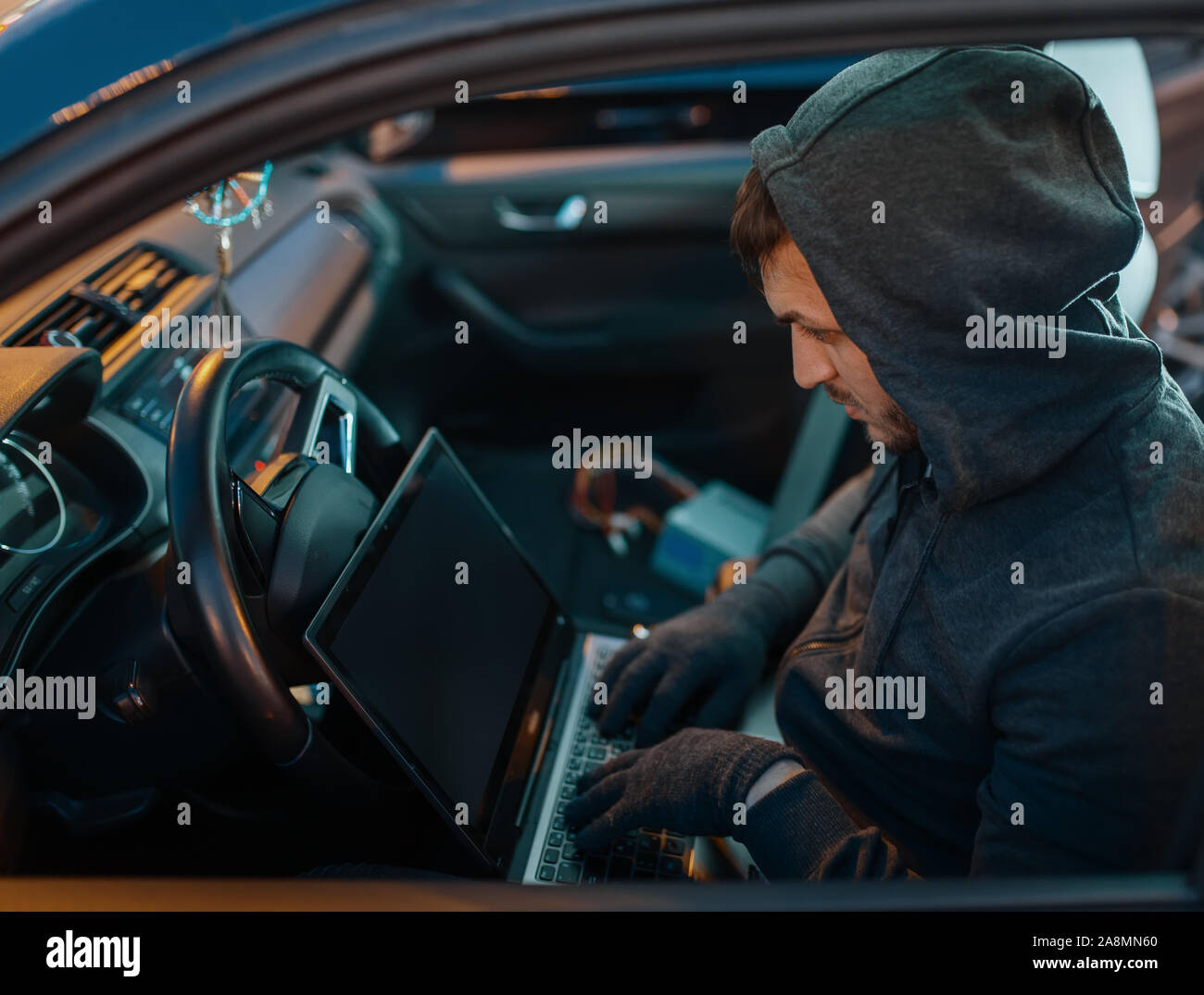 Car thief with laptop hacking security system Stock Photo - Alamy