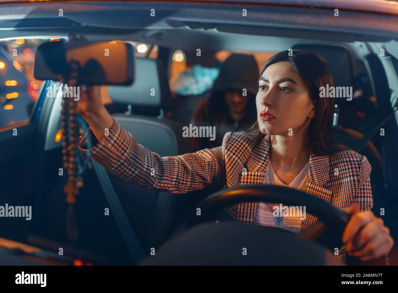 Female driver and hooded car robber on back seat Stock Photo - Alamy