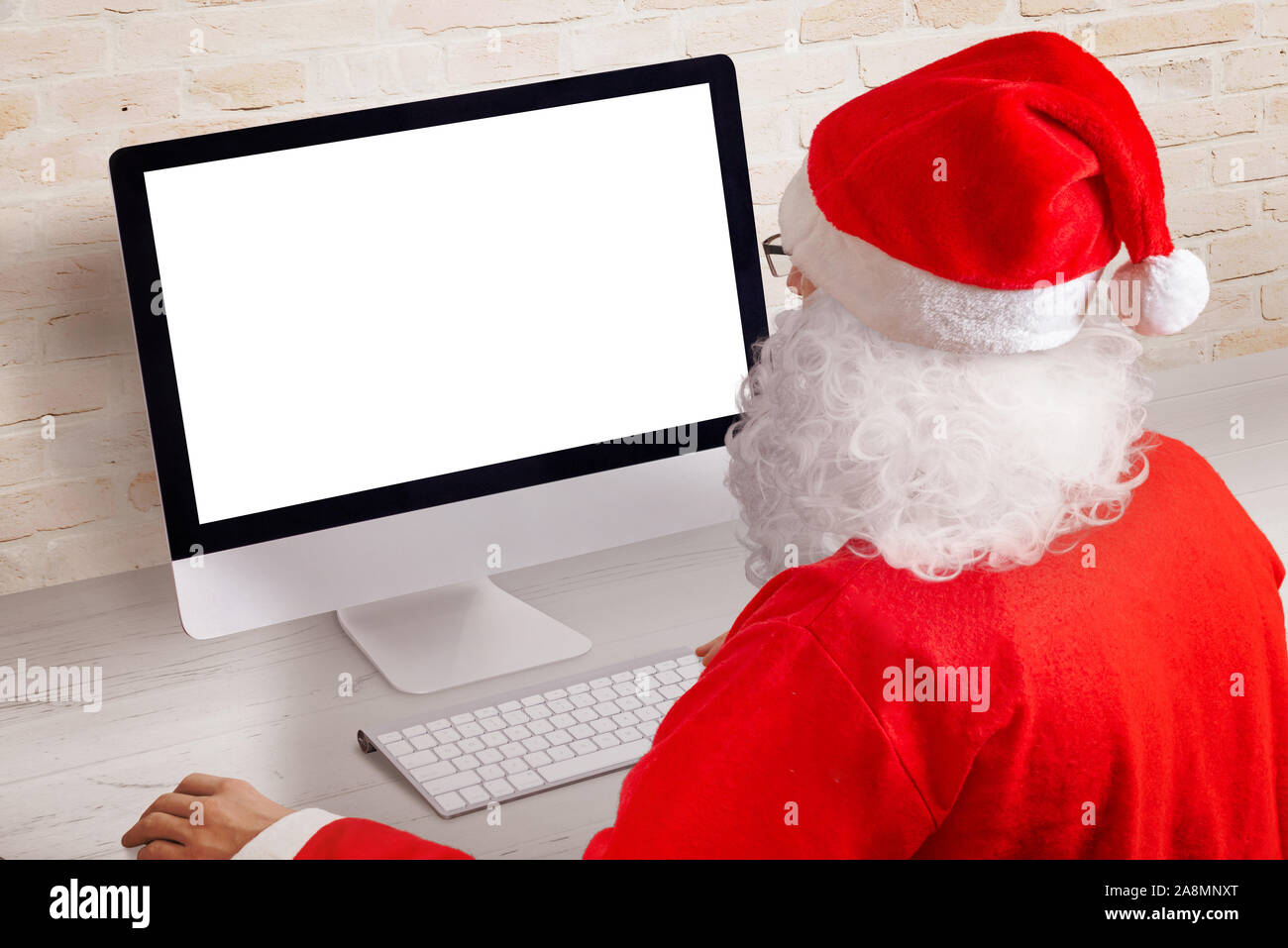 Santa Claus work on computer with isolated screen for mockup. The ...
