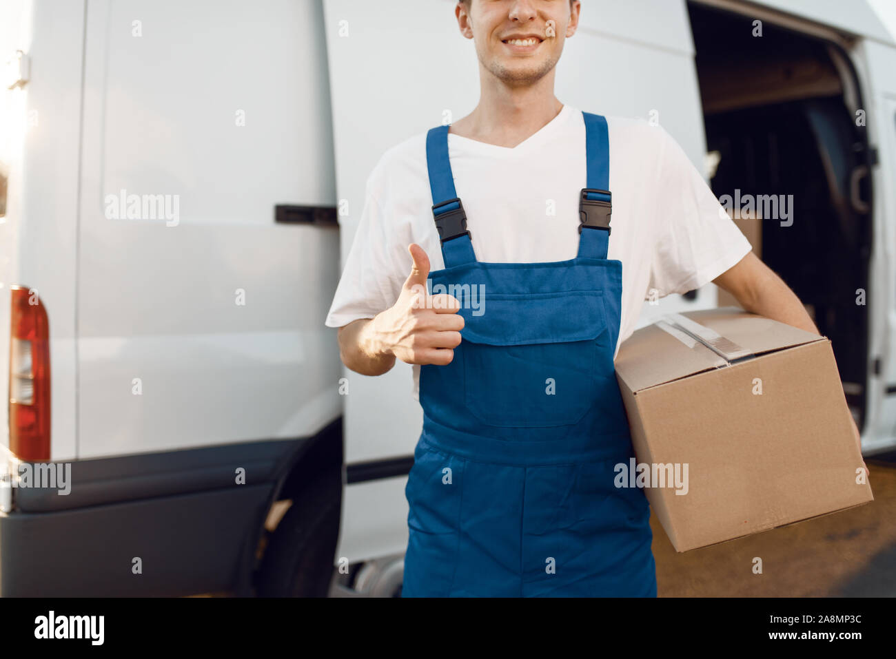 Deliveryman in uniform shows thumbs up, delivery Stock Photo - Alamy