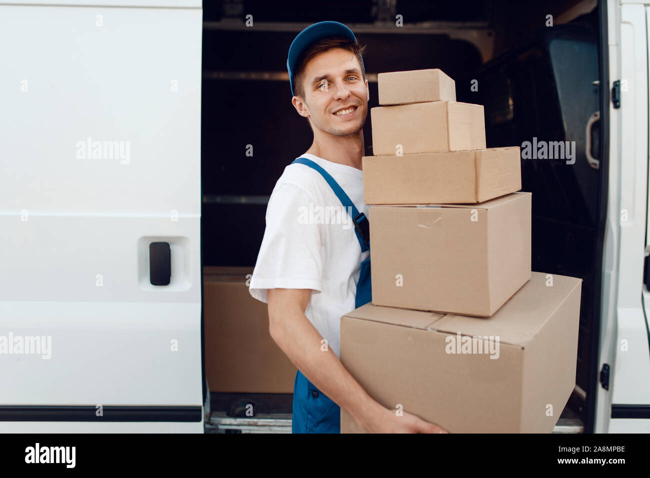 Mailman unloads the car with parcels, delivery Stock Photo - Alamy
