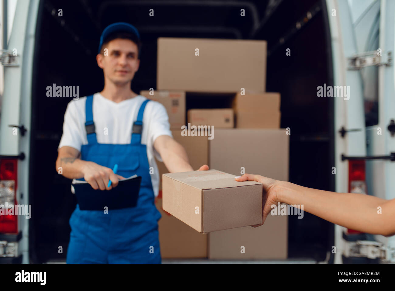 Deliveryman gives parcel to buyer, delivering Stock Photo - Alamy