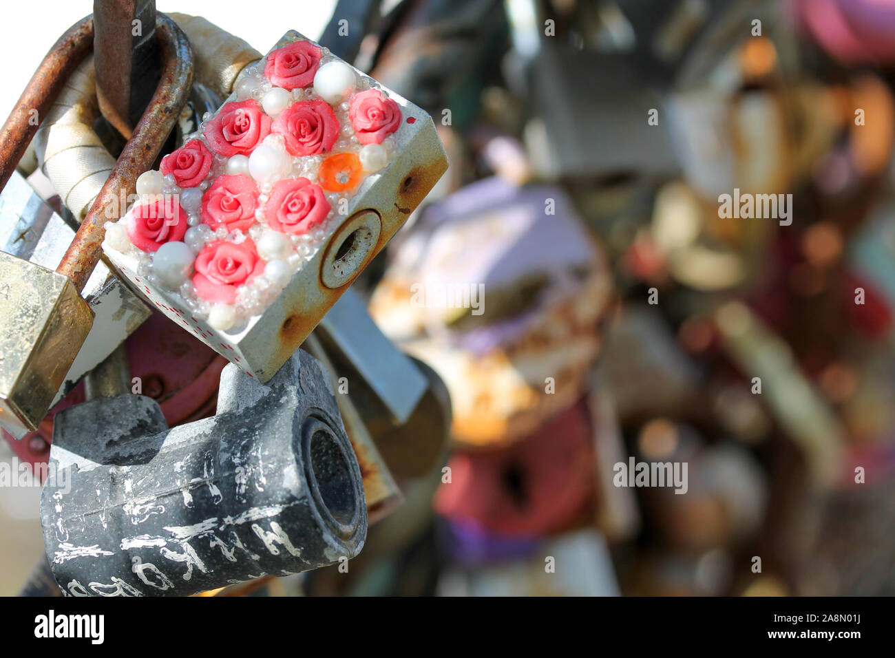 Wedding padlocks chained to the bench in city park. Symbol of love and ...