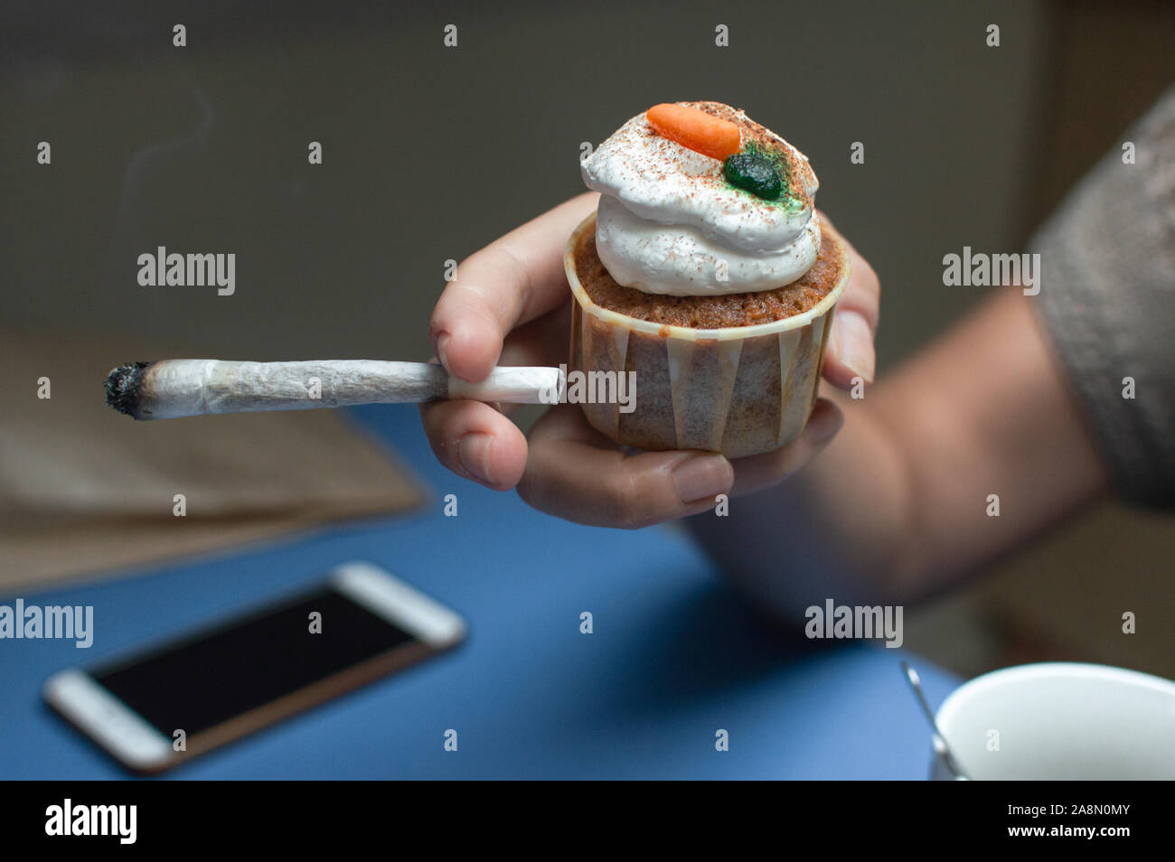 Marijuana and sweets of cannabis. Person eating a space cake and ...