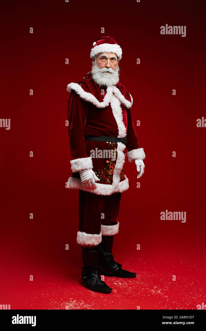 Full length portrait of classic Santa Claus looking at camera while ...