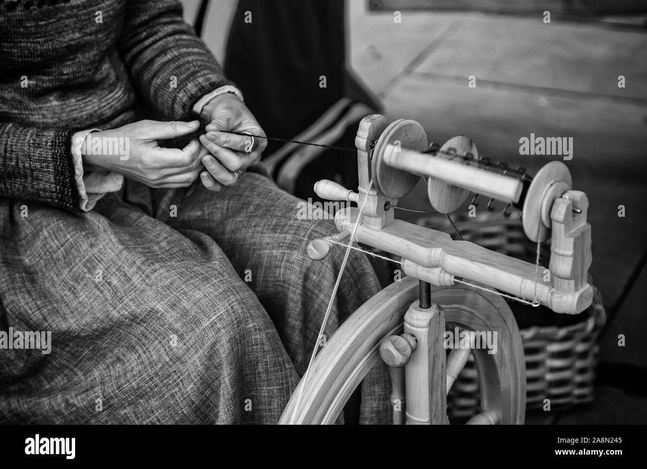 Spinning with a wooden spinning wheel, handicraft detail, thread ...