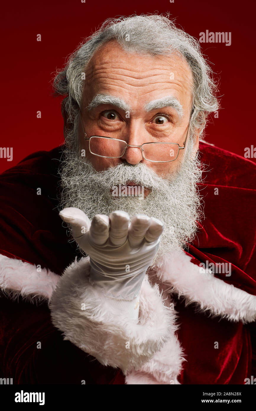 Waist up portrait of classic Santa Claus blowing kisses at camera while ...