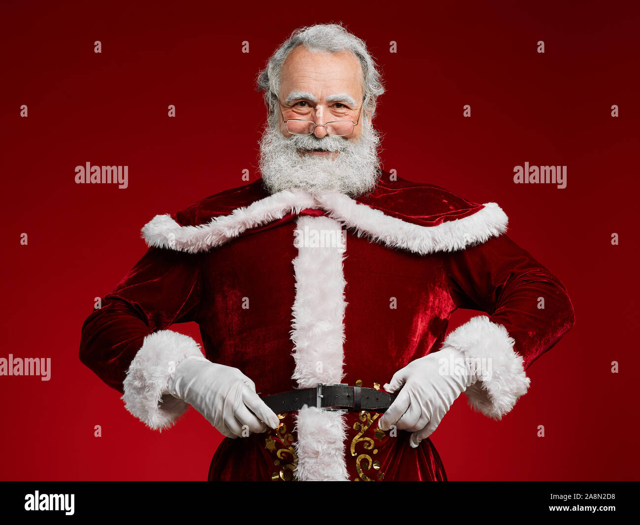 Waist up portrait of smiling Santa Claus standing with hands on hips ...