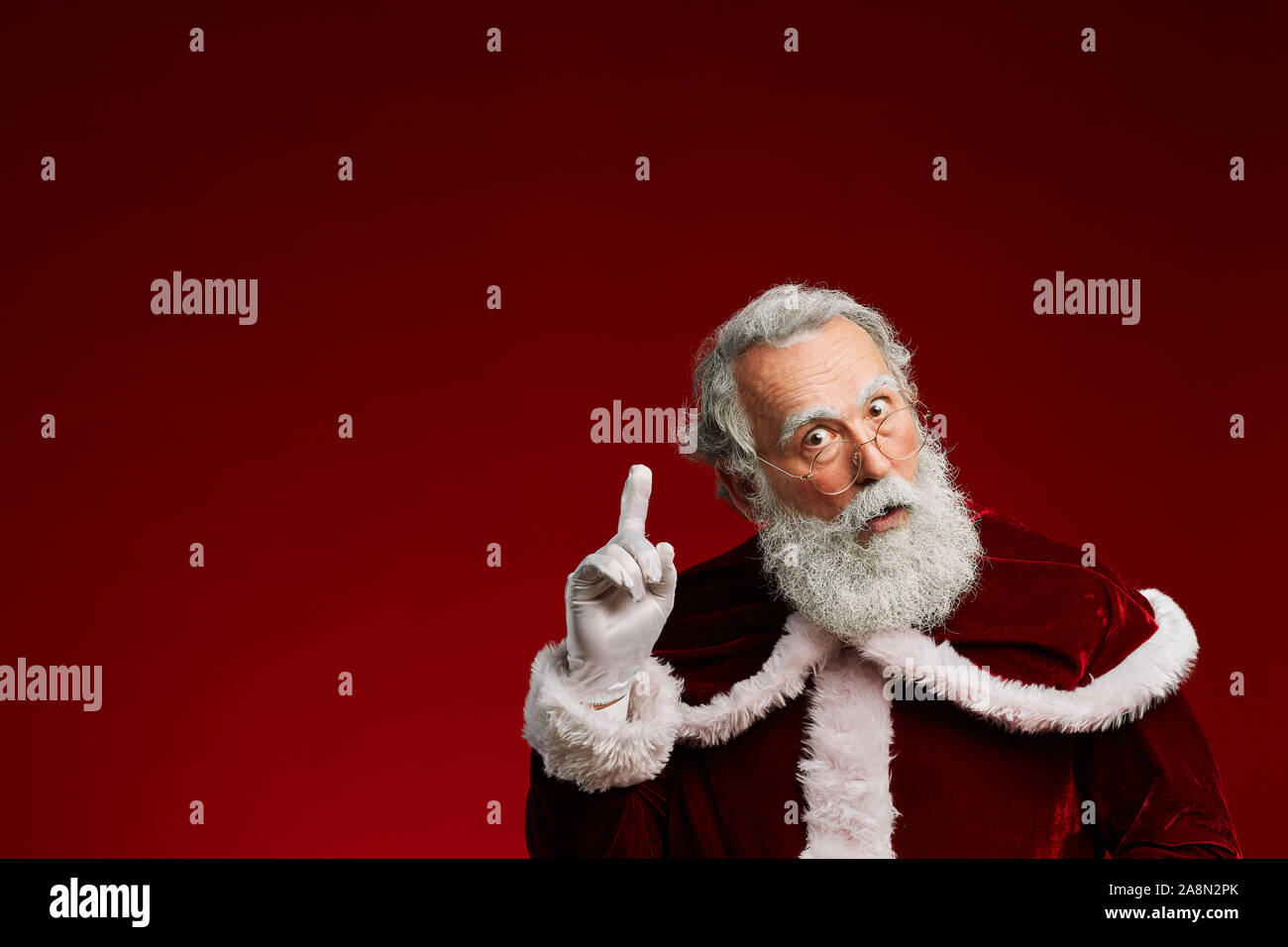 Waist up portrait of surprised Santa Claus pointing up while posing ...
