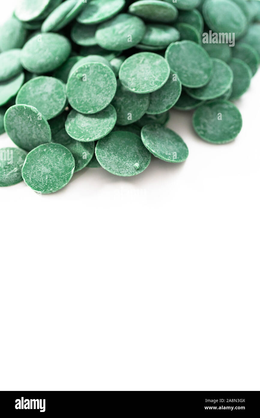 Green round chocolate chips for melting chocolate shapes on a white ...