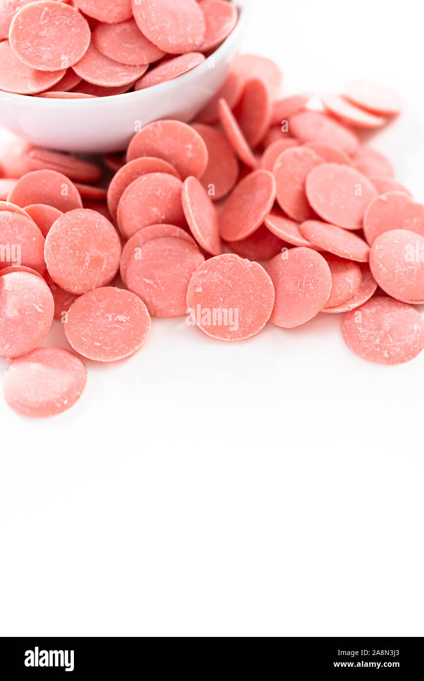 Pink round chocolate chips for melting chocolate shapes on a white ...