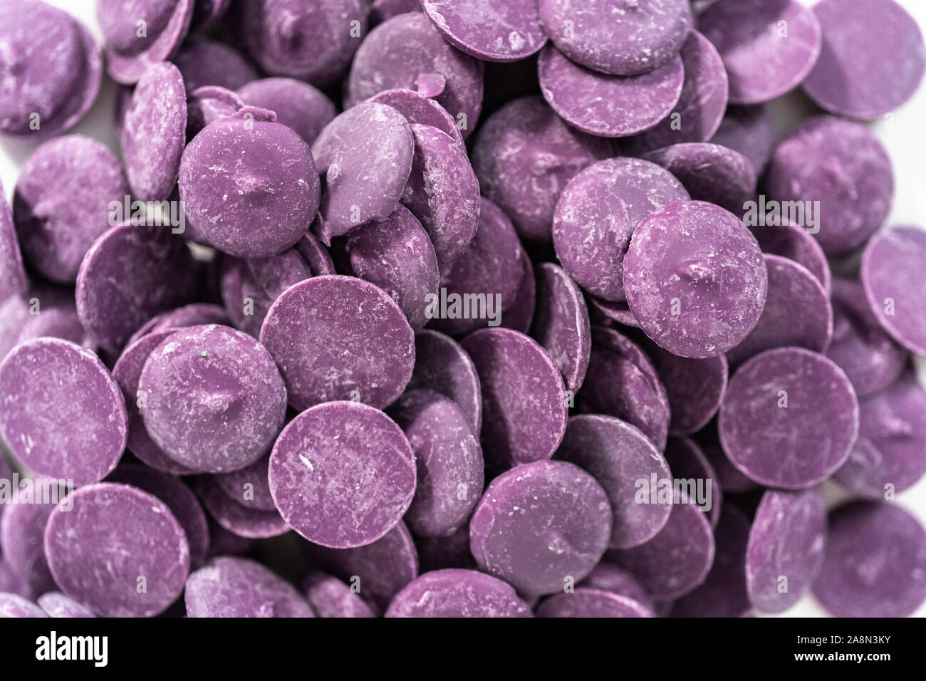 Purple round chocolate chips for melting chocolate shapes on a white ...
